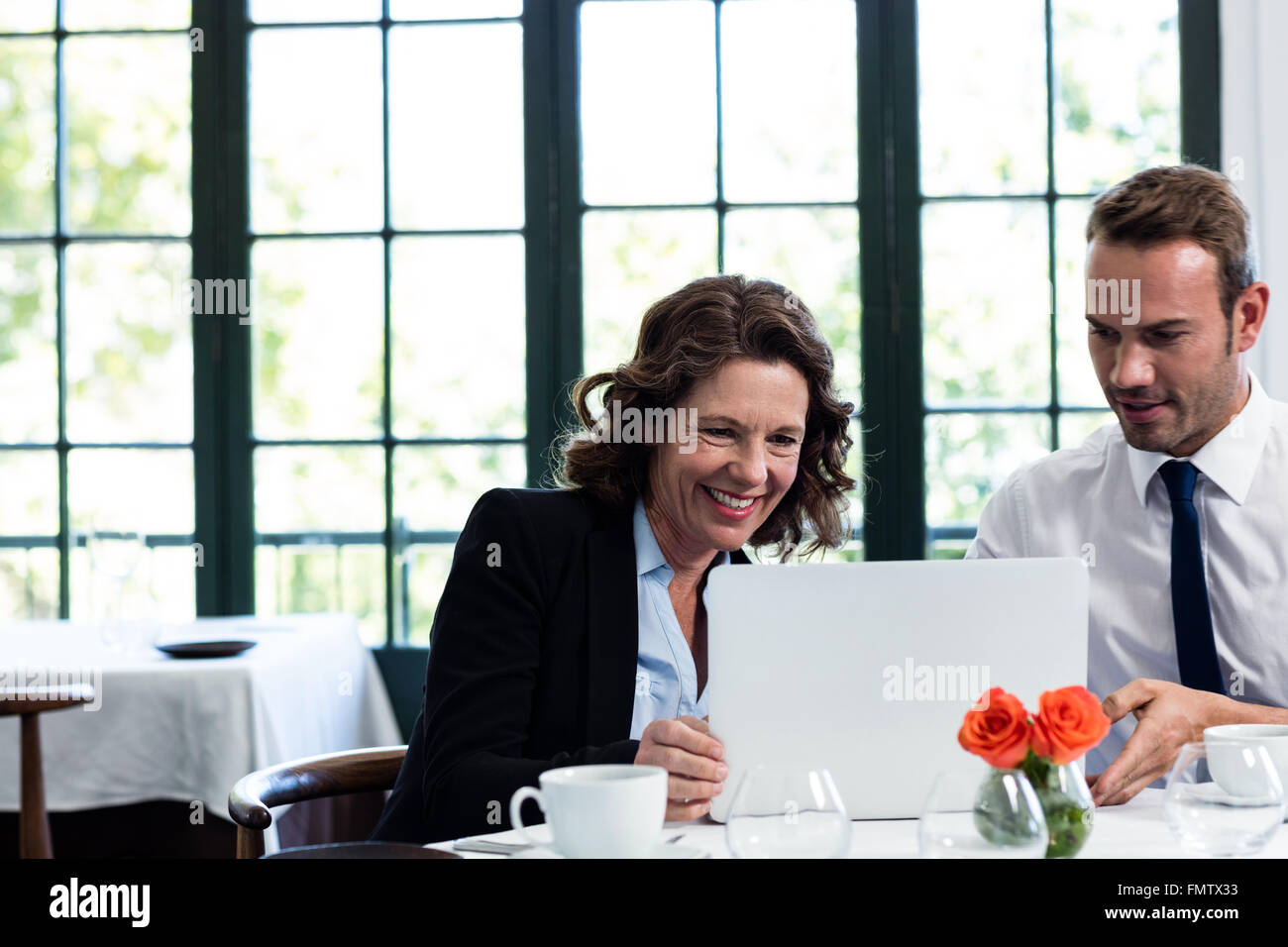 Business colleagues using a laptop while having a meeting Stock Photo ...