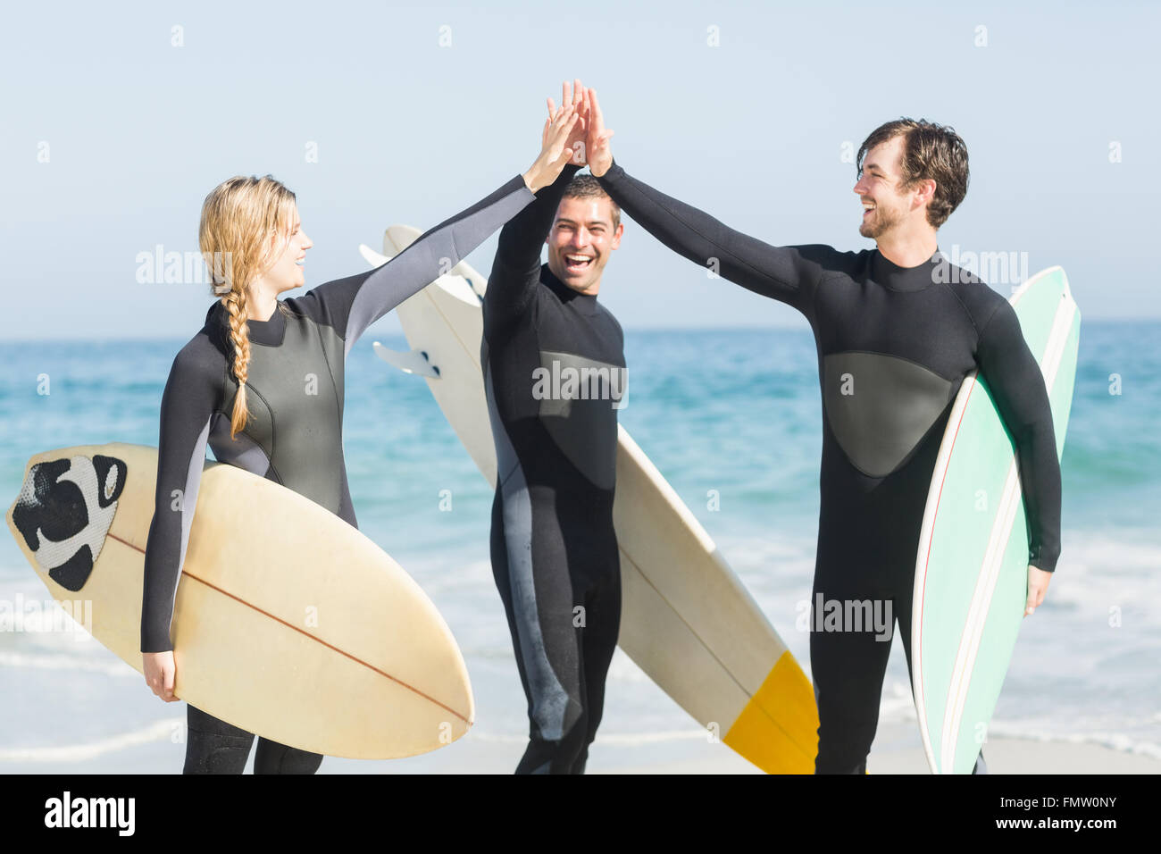 Happy surfer giving high-five to each other on the beach Stock Photo ...