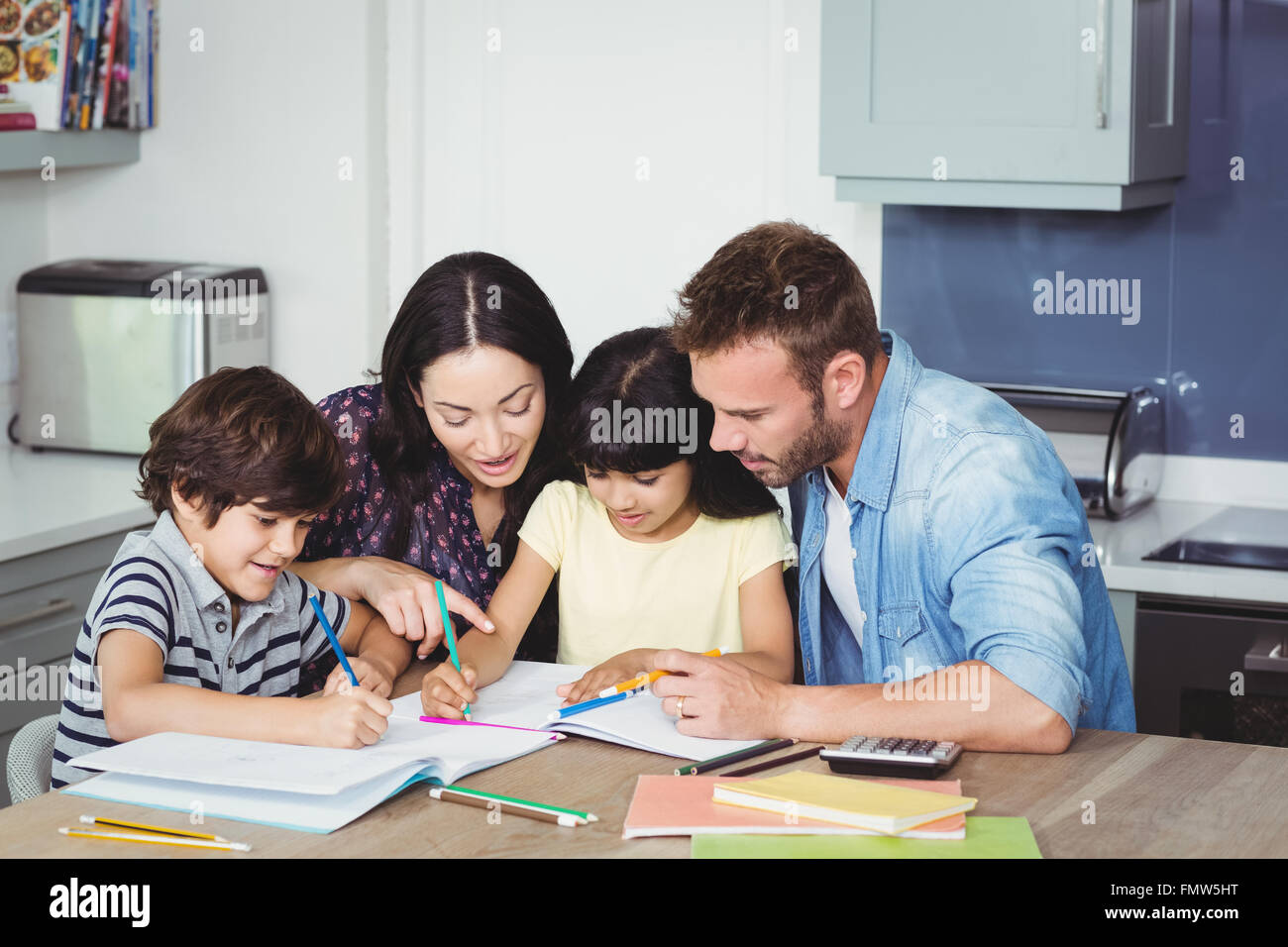 Parents helping children in doing homework Stock Photo - Alamy