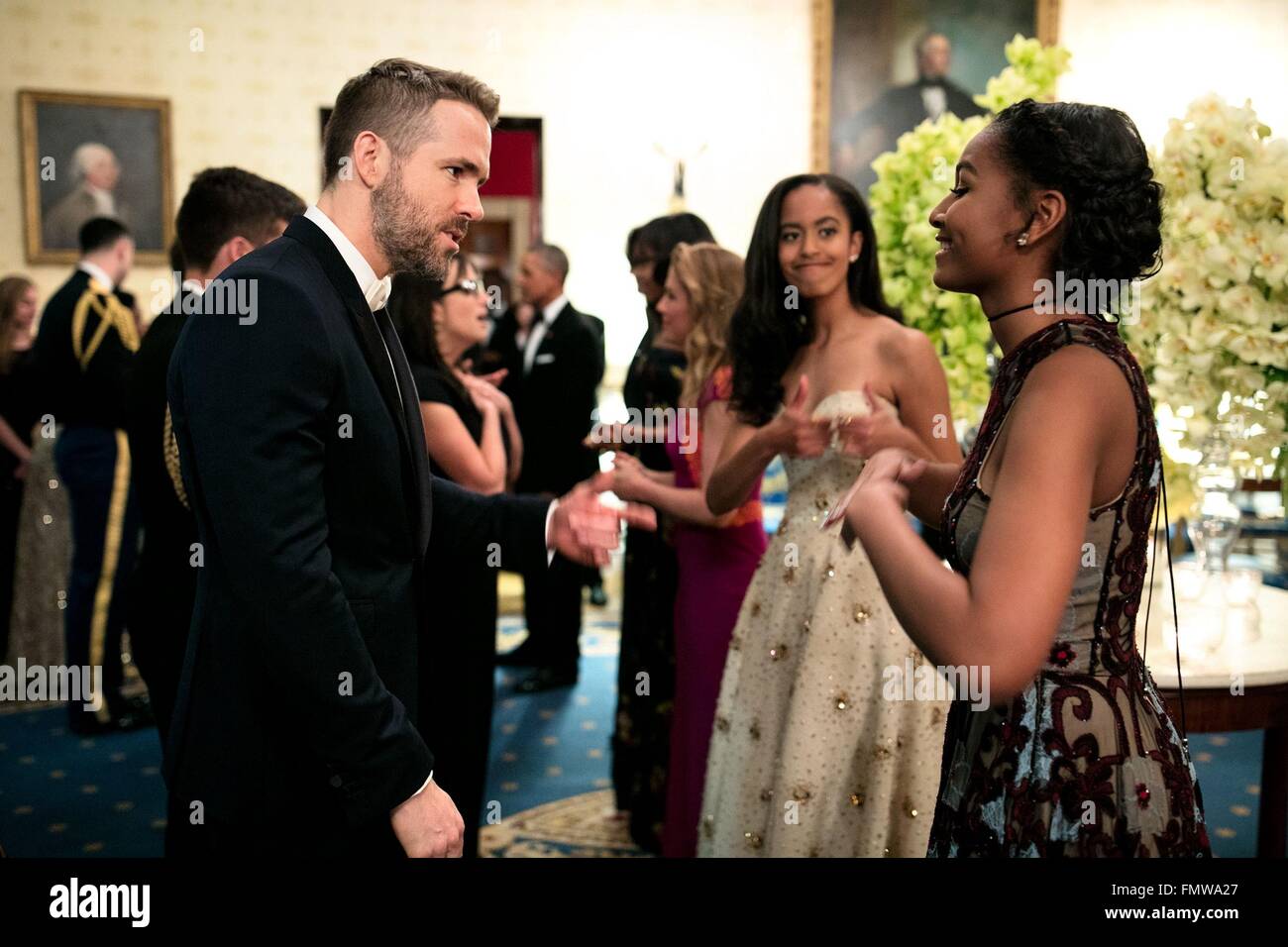 Malia and Sasha Obama speak with actor Ryan Reynolds during a reception ...
