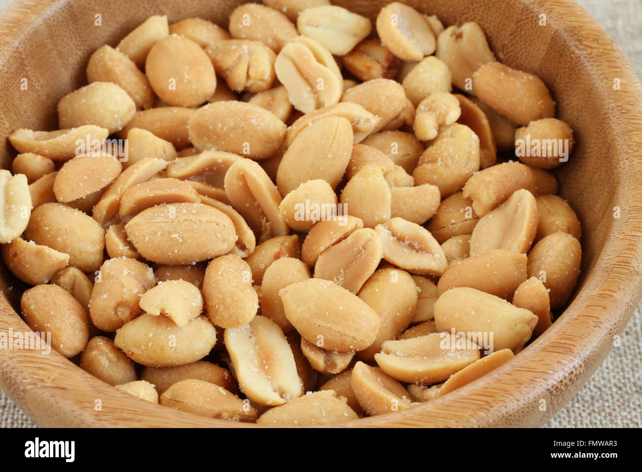 Salted roasted peanuts in bamboo bowl on rough linen cloth Stock Photo ...