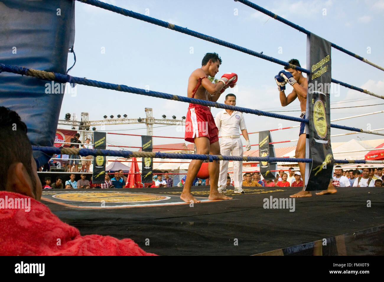 Two Muay Thai boxers are boxing in a boxing ring at a festival Kampong ...