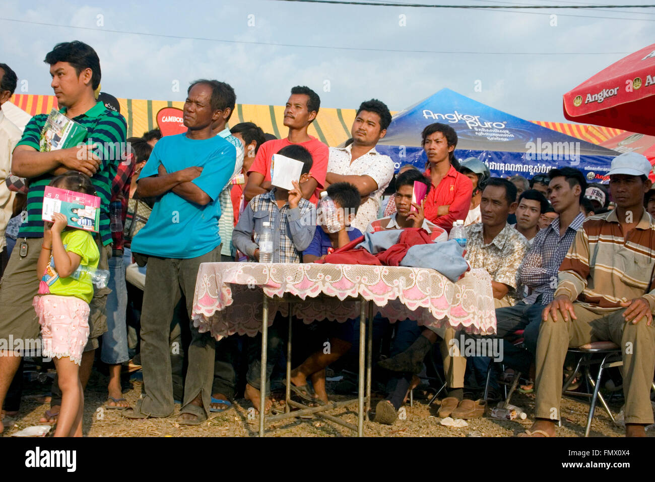 A crowd of fans watch two Muay Thai boxers in a boxing ring at a ...