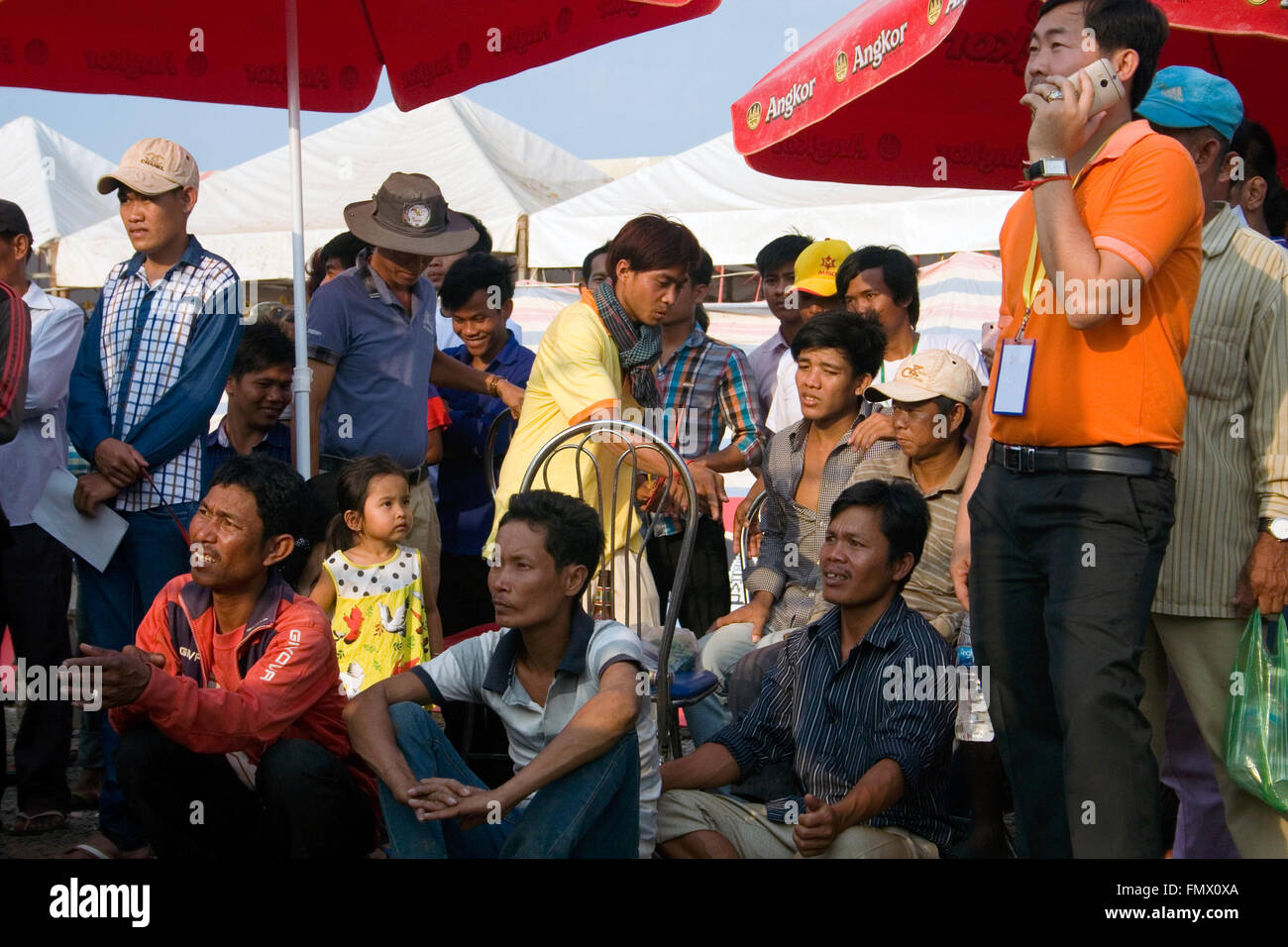 A crowd of fans watch two Muay Thai boxers in a boxing ring at a ...