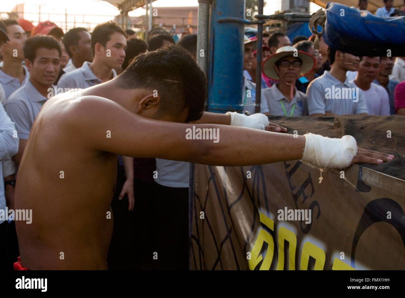 A Muay Thai boxer is preparing to enter a boxing ring for a boxing ...