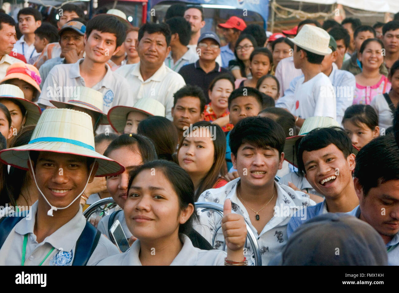 A crowd of fans watch two Muay Thai boxers in a boxing ring at a ...