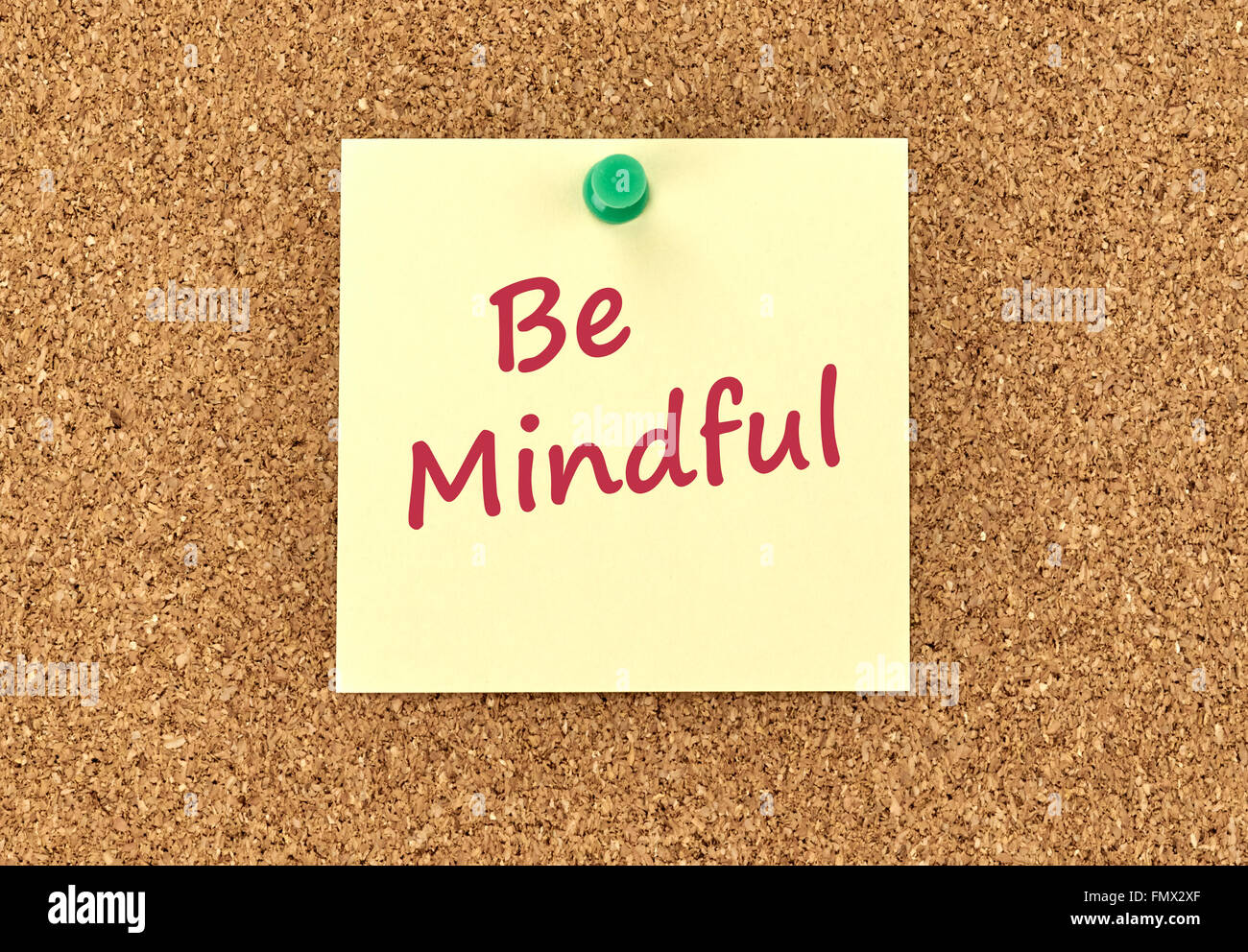 The phrase Be Mindful in red text on a yellow sticky note posted to a ...