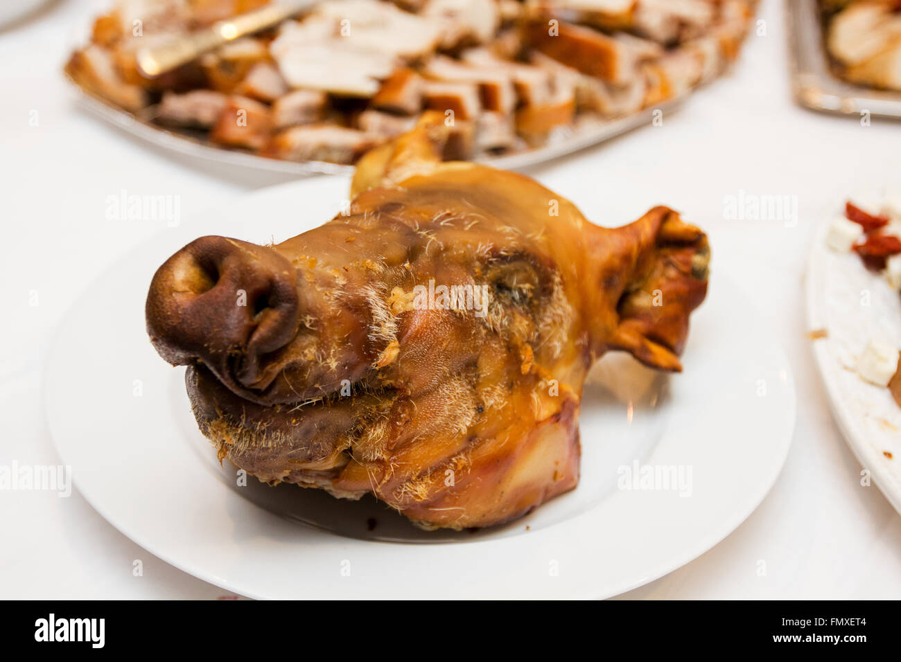 Roasted pig head, serving on white plate Stock Photo - Alamy