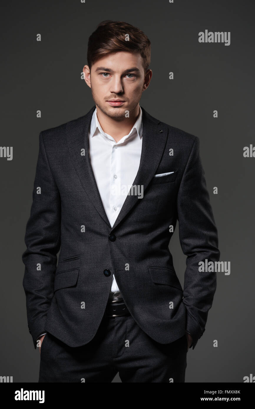 Portrait of confudent young businesssman in black suit and white shirt ...