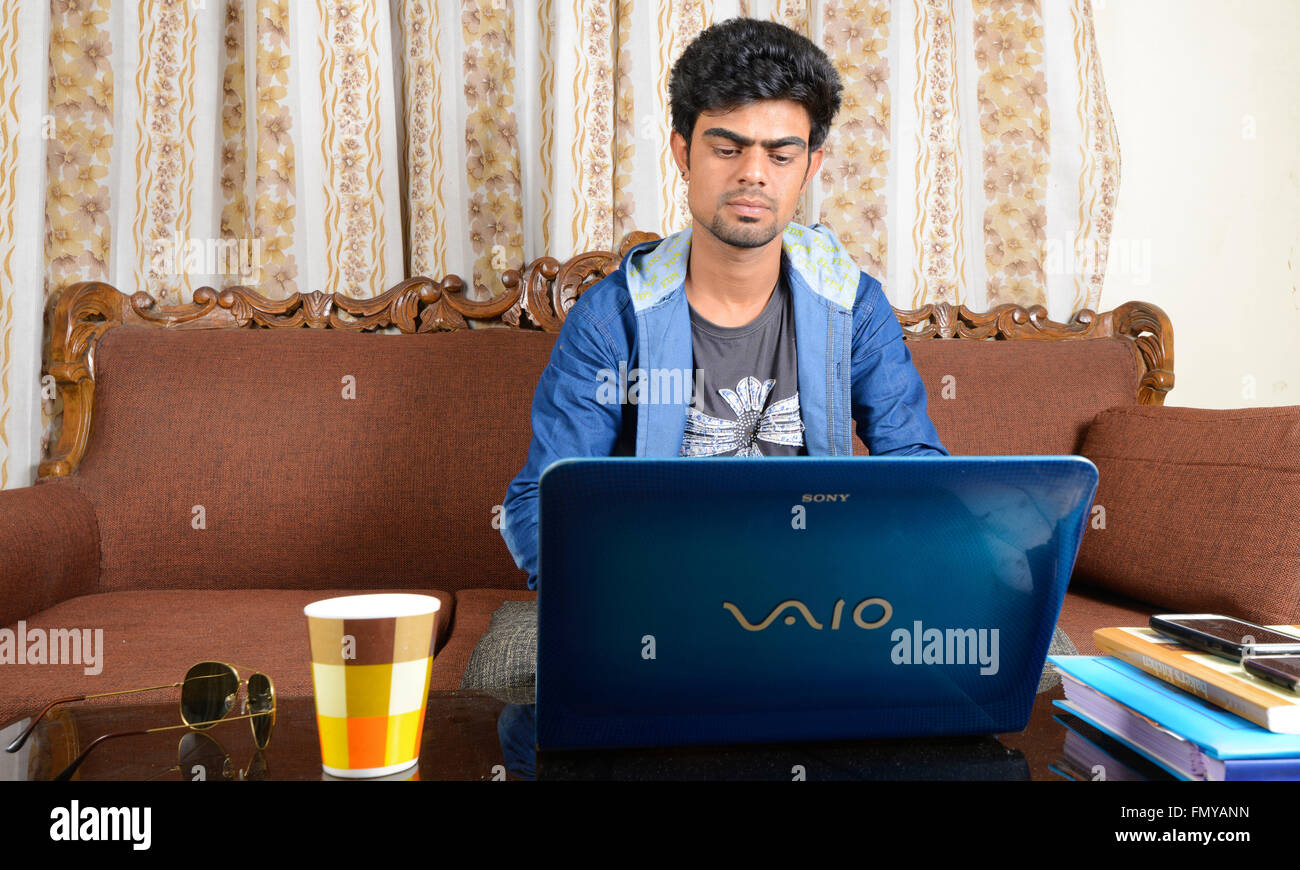 Young guy using laptop at Home Stock Photo - Alamy