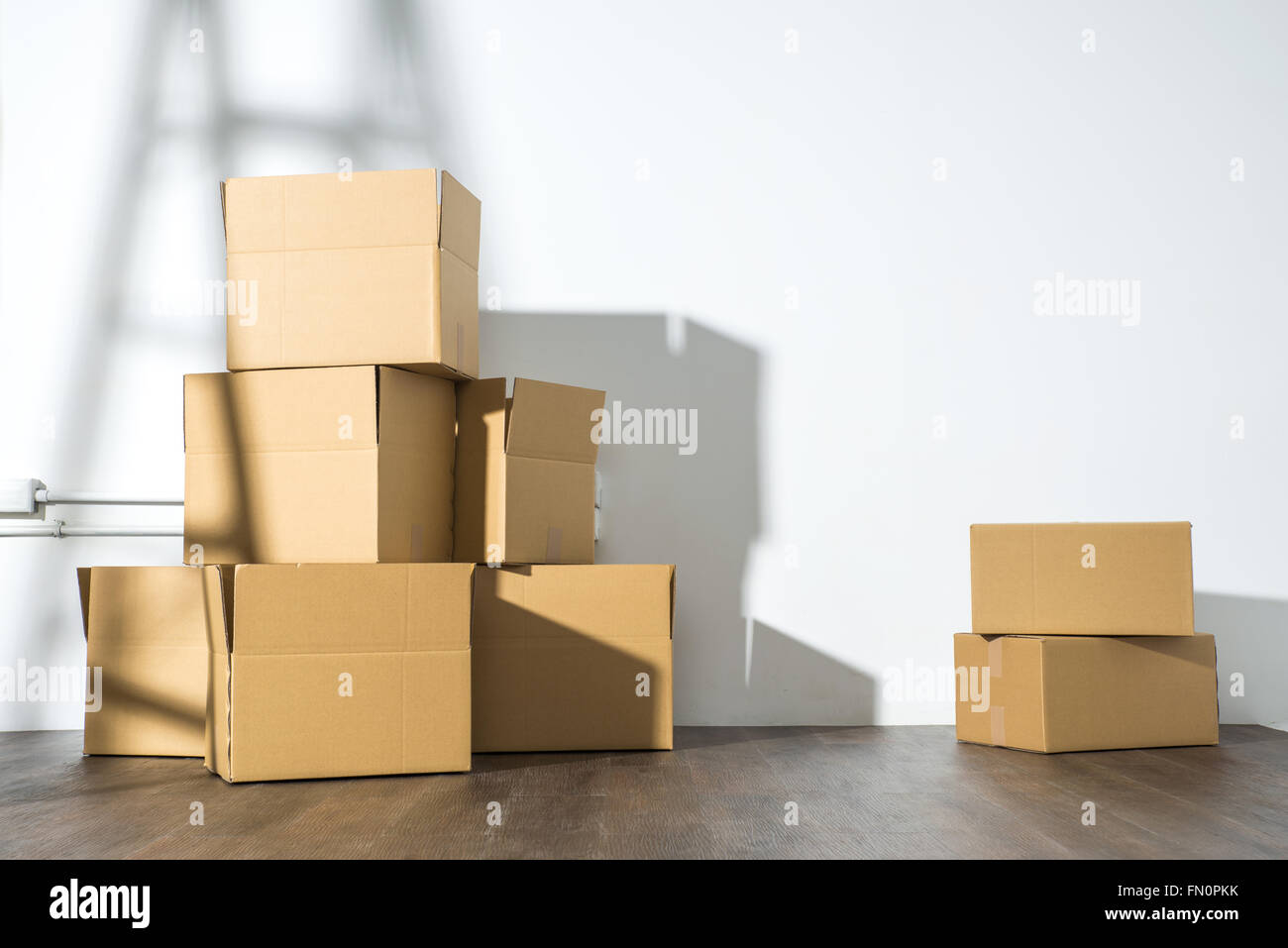Pile of cardboard boxes on white background with Ladder shadow, nobody ...