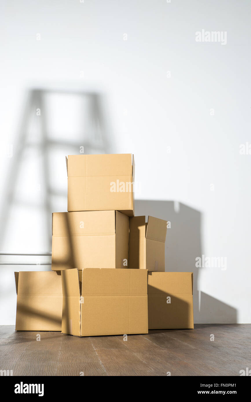Pile of cardboard boxes on white background with Ladder shadow, nobody ...
