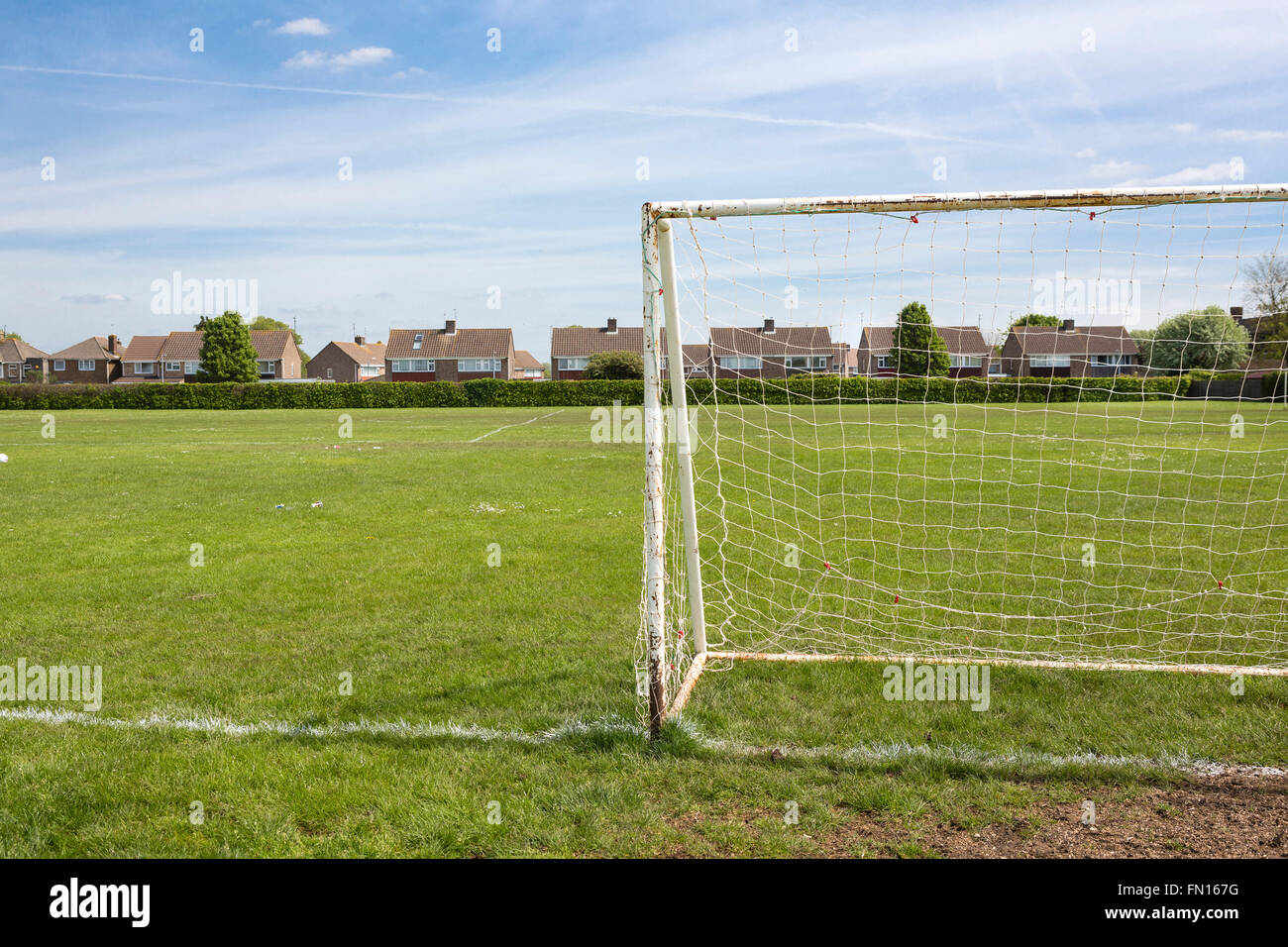 An empty playing field surrounded by housing and hedges Stock Photo - Alamy
