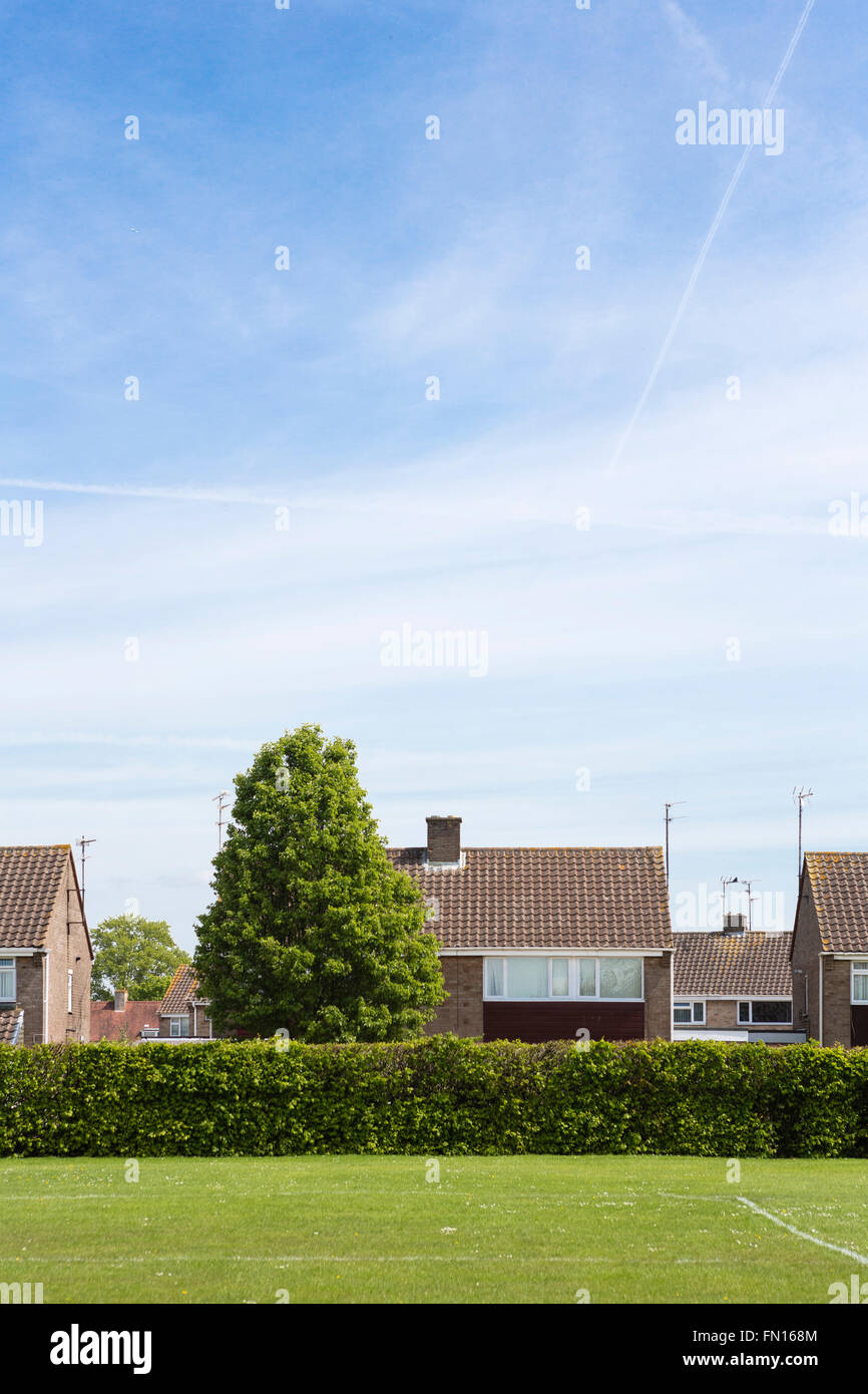 An empty playing field surrounded by housing and hedges Stock Photo - Alamy
