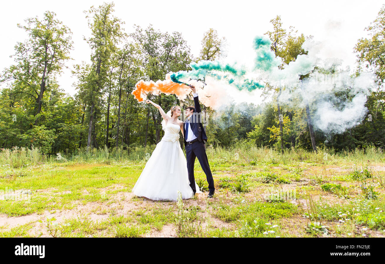 Wedding couple with color smoke in the summer park Stock Photo - Alamy