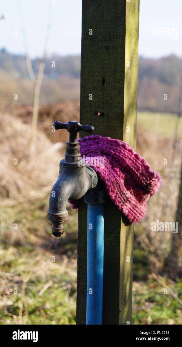 Outdoor water tap attached to a wooden post Stock Photo - Alamy