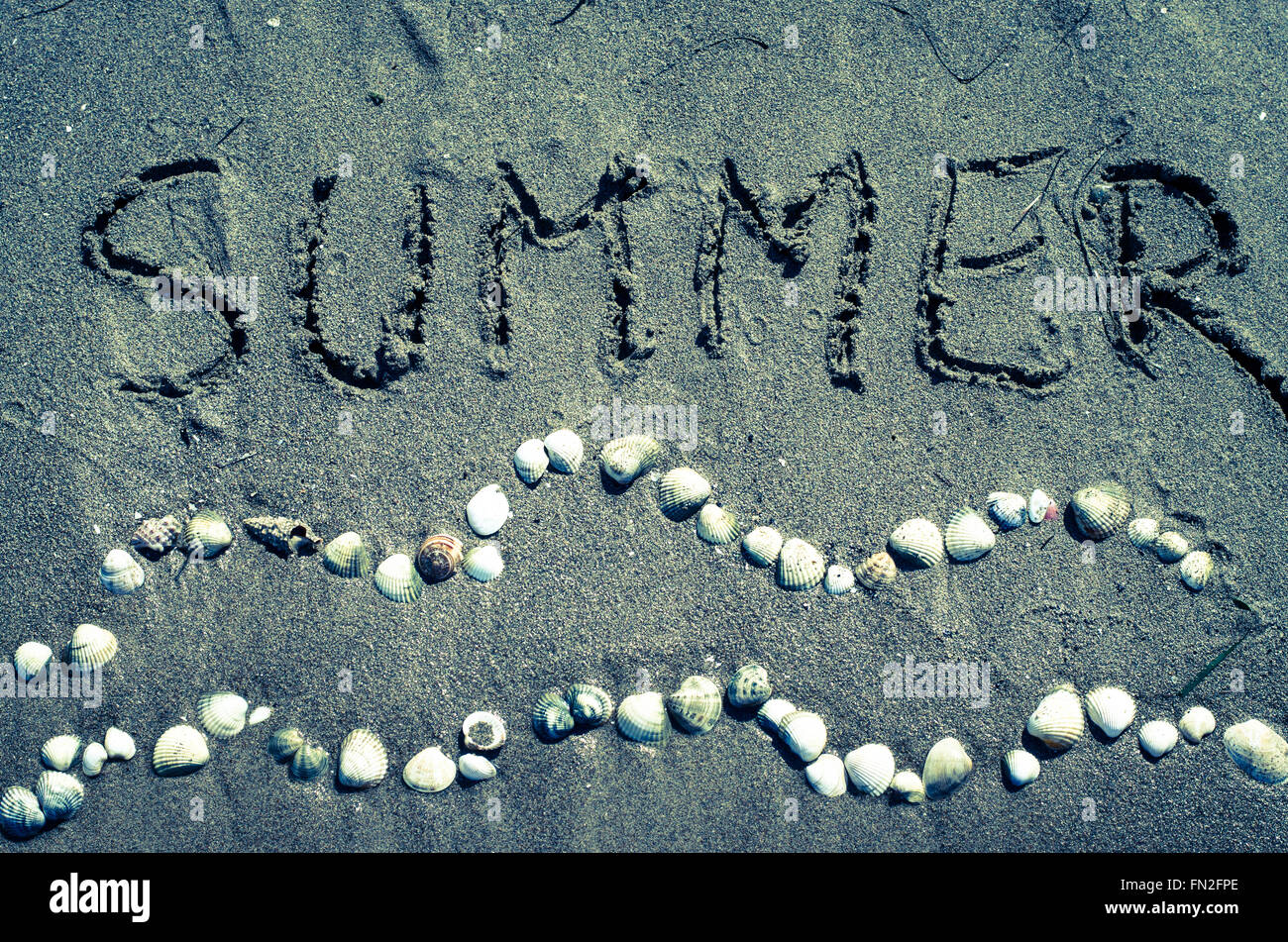 waves from shells and summer word on sand on beach Stock Photo - Alamy