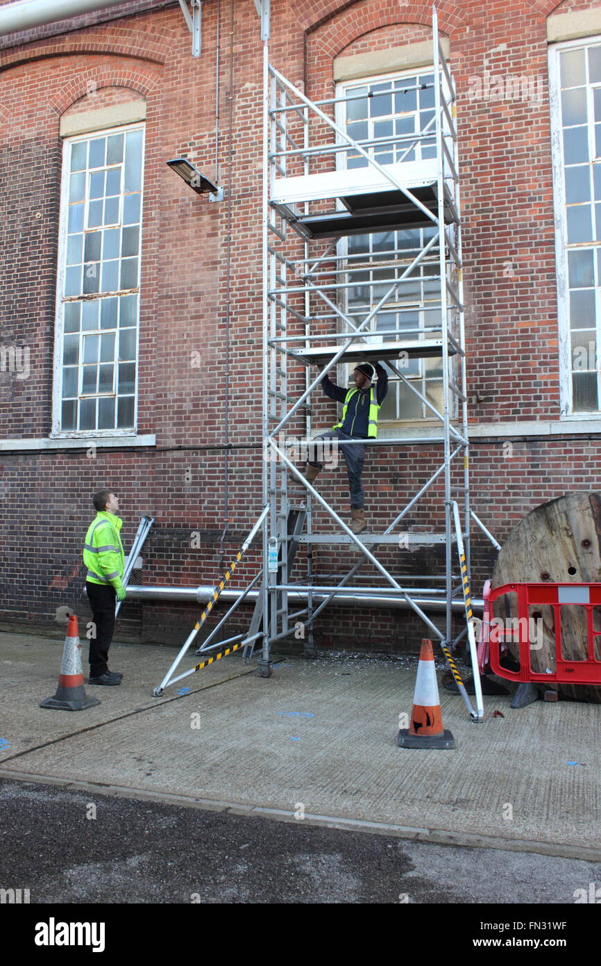 Two engineers correctly building a scaffold tower Stock Photo - Alamy