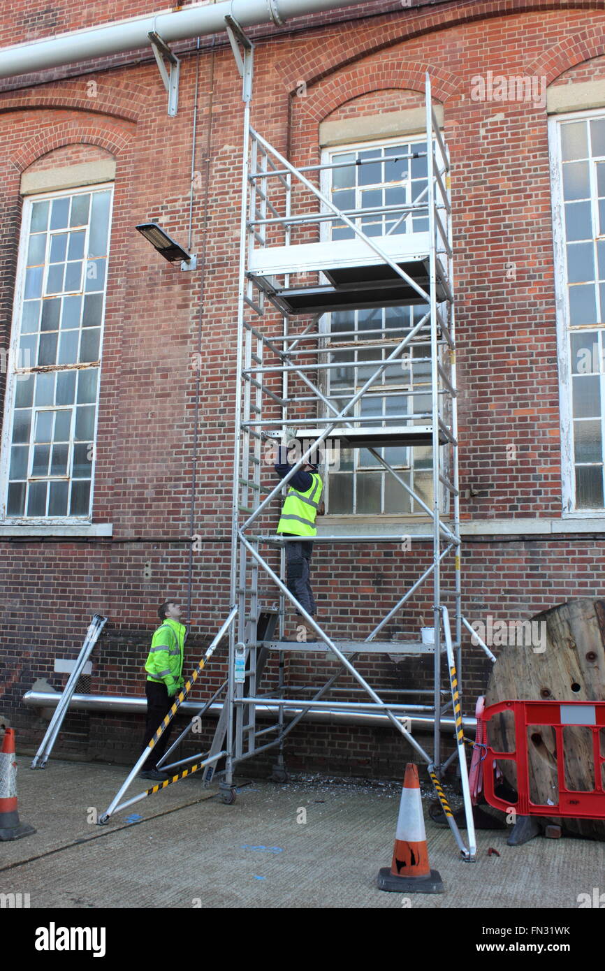 Two engineers correctly building a scaffold tower Stock Photo - Alamy