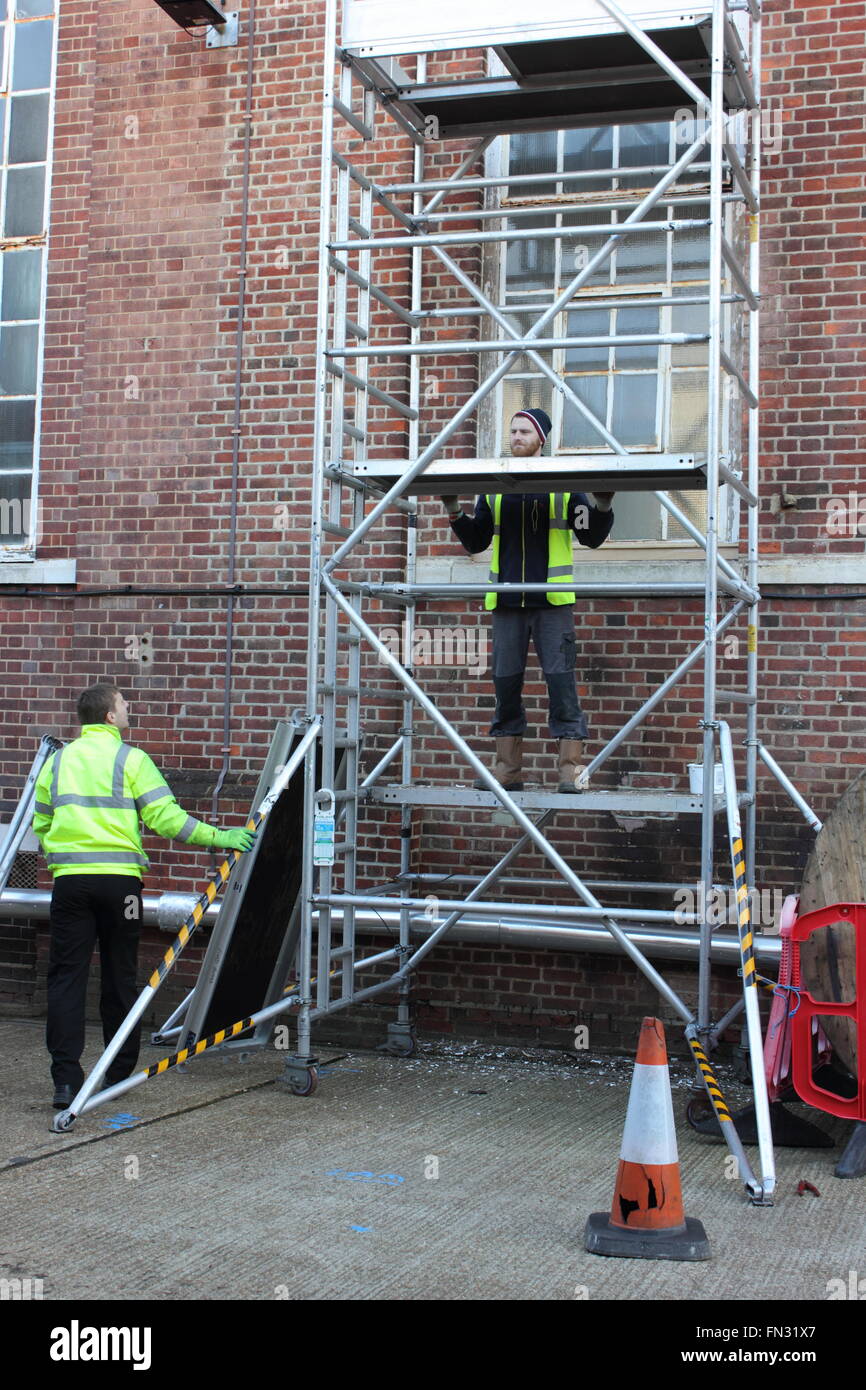 Two engineers correctly building a scaffold tower Stock Photo - Alamy