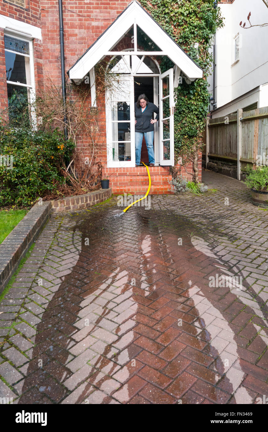 Woman pumping out her flooded cellar after a period of rain Stock Photo ...