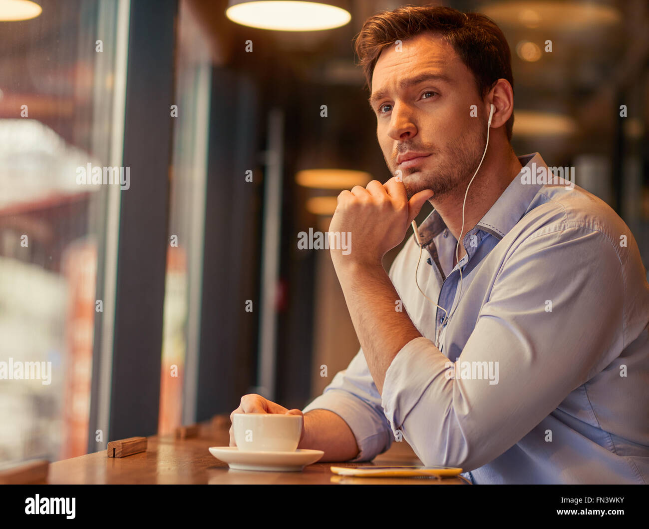 Reflective man drinking coffee Stock Photo - Alamy