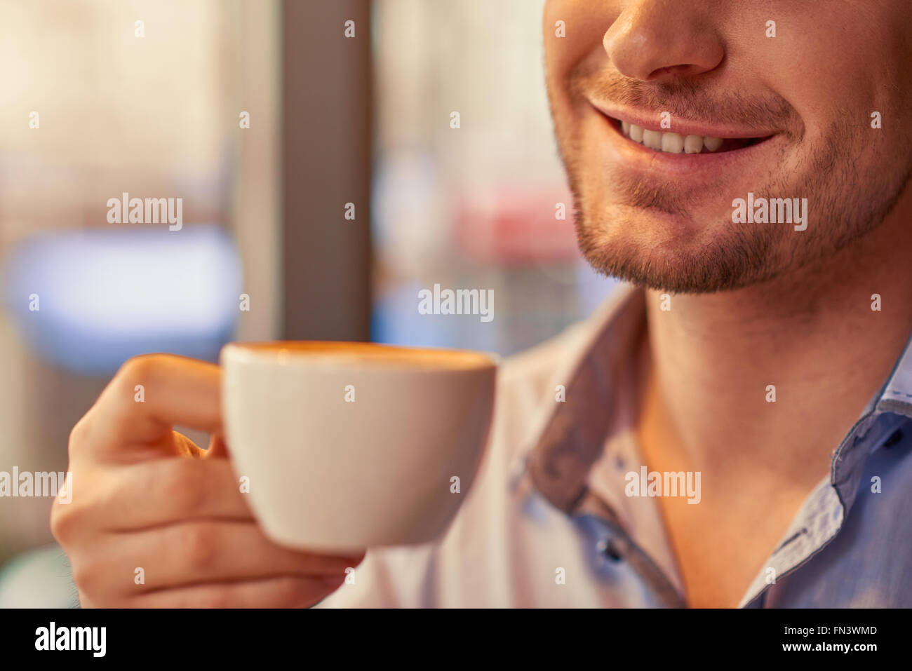 Positive man drinking coffee Stock Photo - Alamy