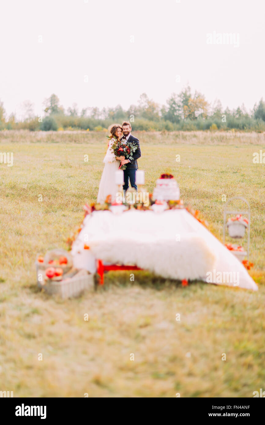 Bride and groom on the creative wedding ceremony. Field background ...