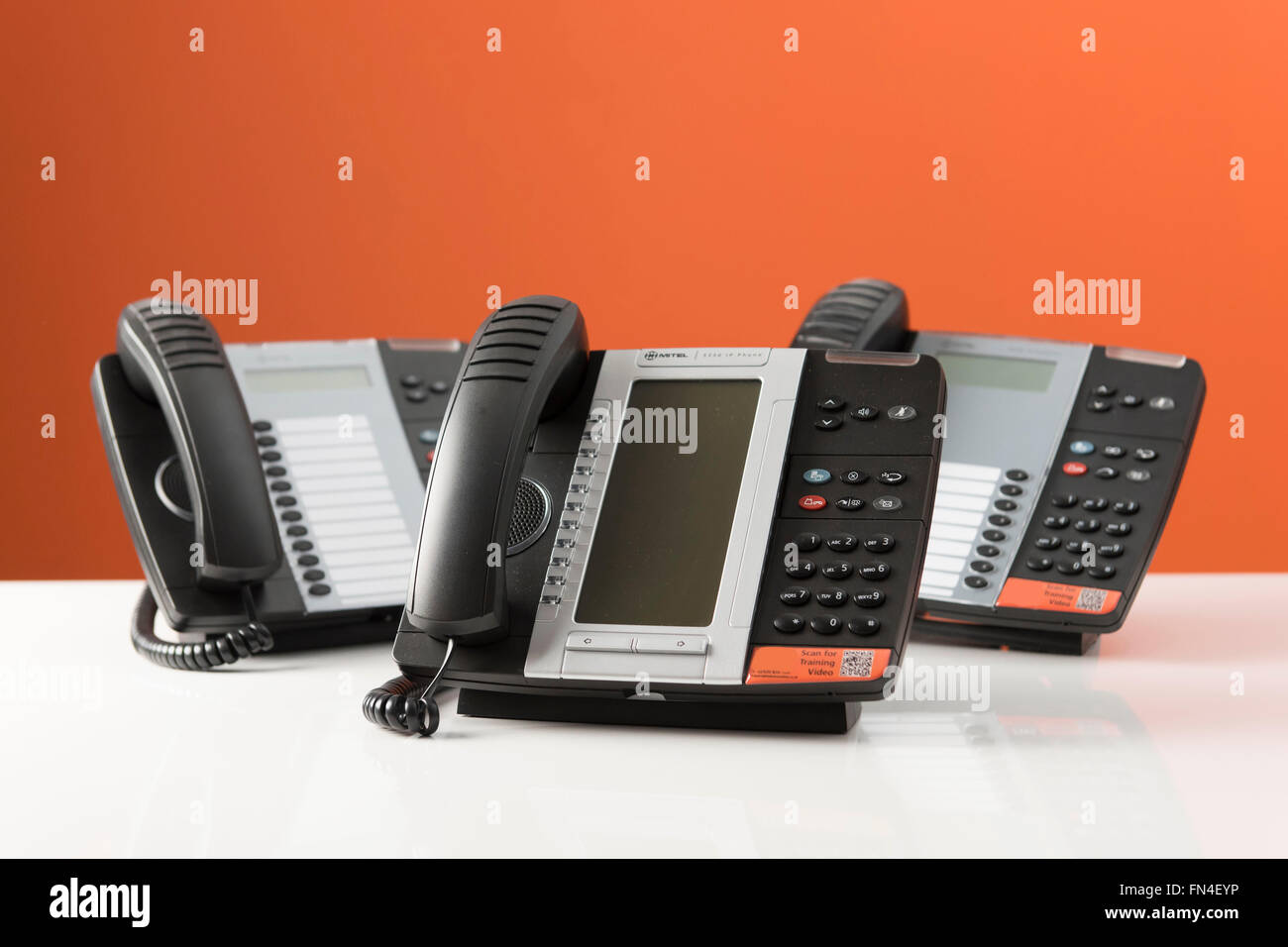 Office phone on an orange background Stock Photo - Alamy