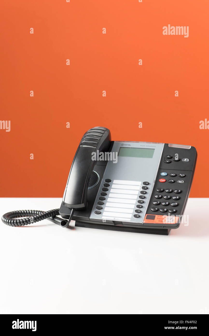 Office phone on an orange background Stock Photo - Alamy