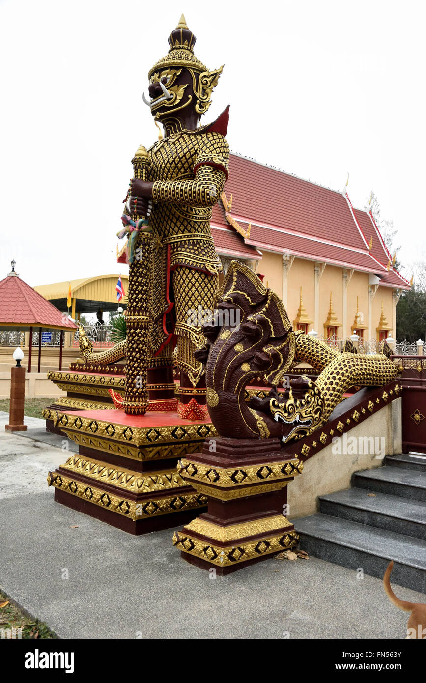 A giant temple guardian in front of a small hall next to the main ...
