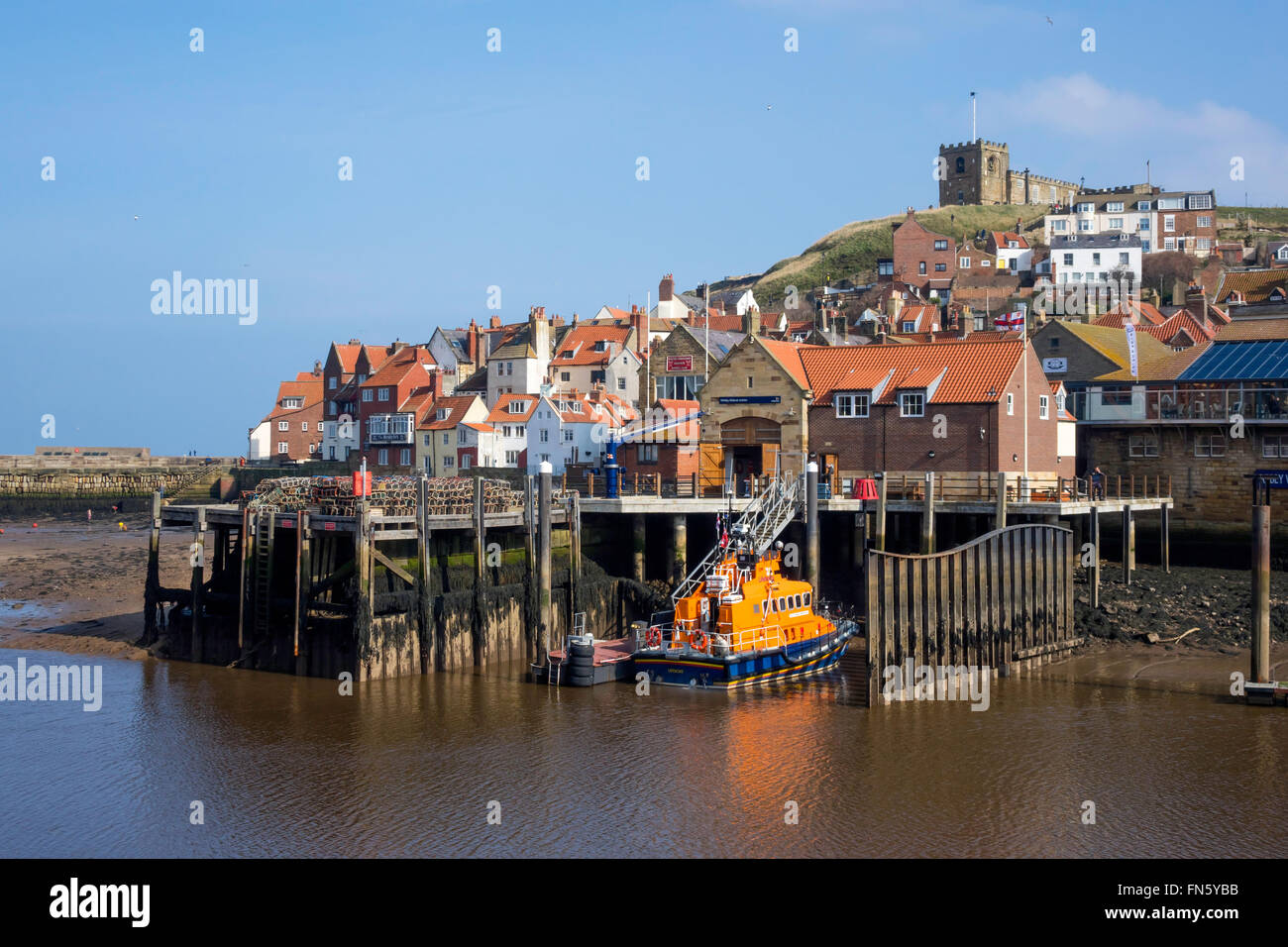 Whitby harbour with the lifeboat station and St Mary's church in spring ...