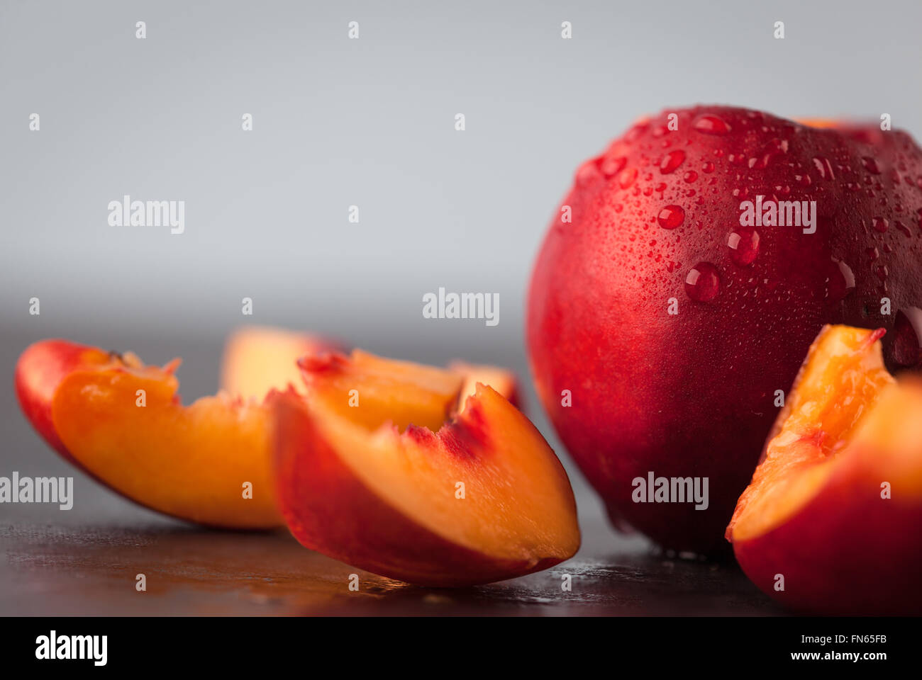 Closeup of yellow nectarine peach slices and whole fruit with water ...