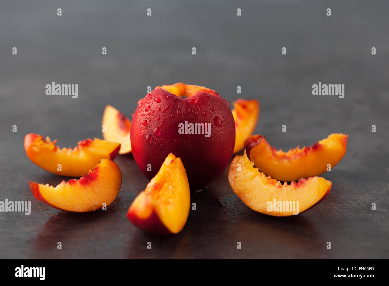 Yellow nectarine peach - whole fruit and slices on dark grungy ...