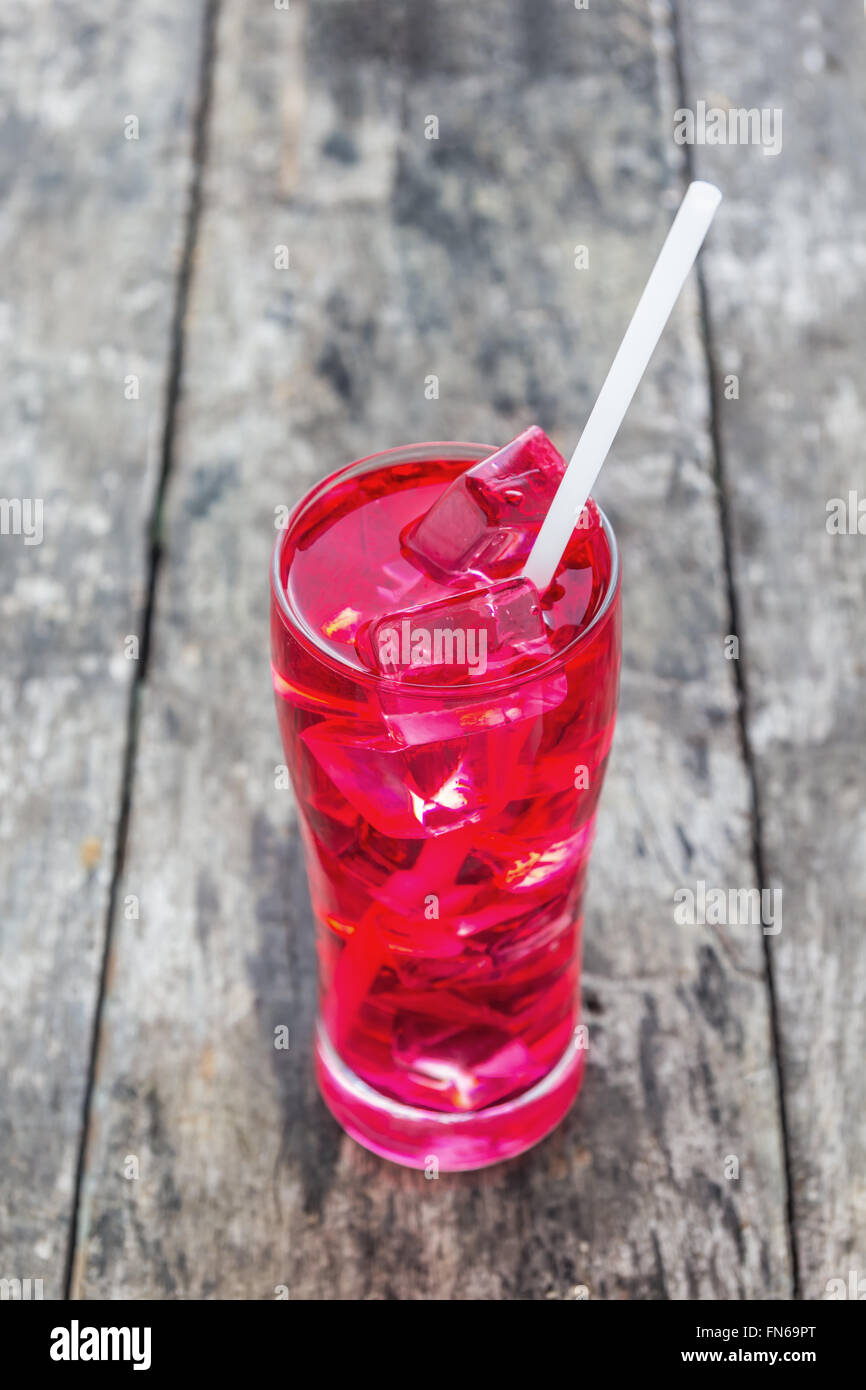 A photo of Red juice in a glass with ice on wooden table Stock Photo ...