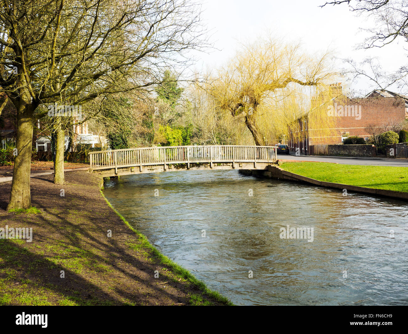 Footbridge over the River Itchen in central Winchester showing park are ...