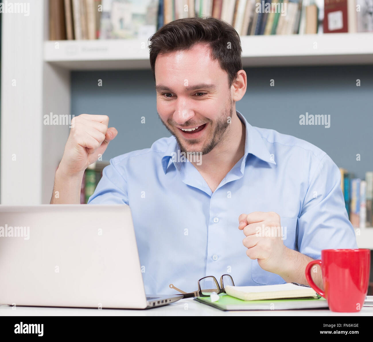 Happy student in library Stock Photo - Alamy