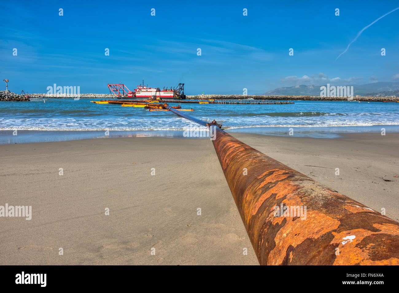 Dredge barge beyond the rusty pipes Stock Photo - Alamy