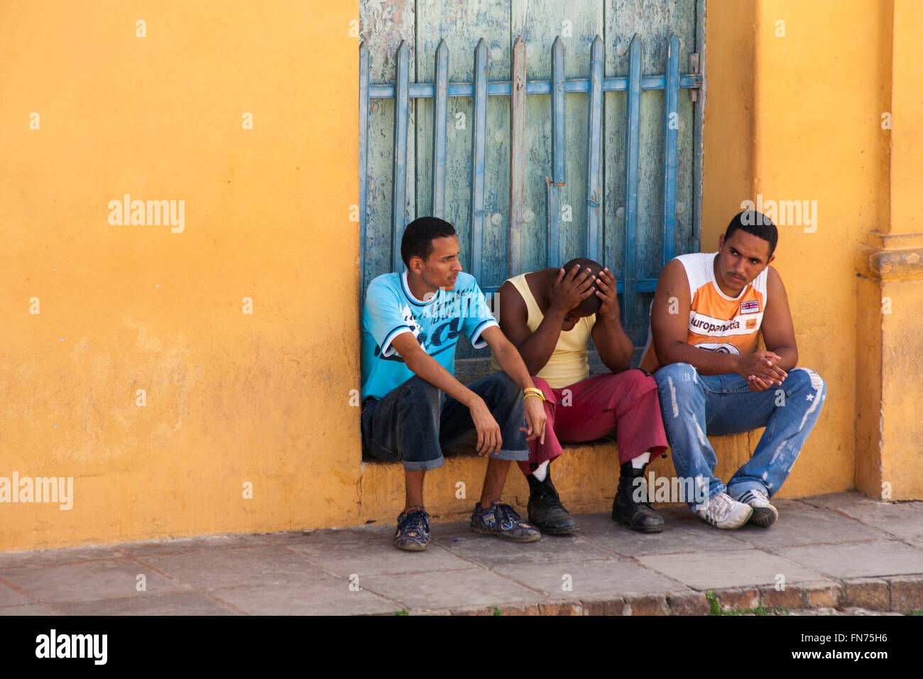 Daily life in Cuba - young men sat on steps at Trinidad, Cuba, West ...