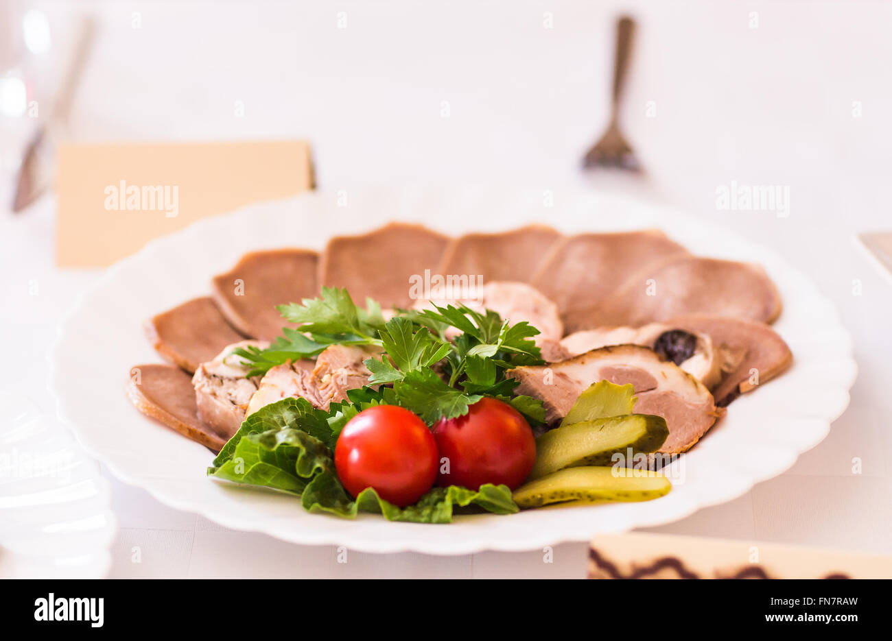 catering platter of sliced cured meat and ham with vegetable decoration ...