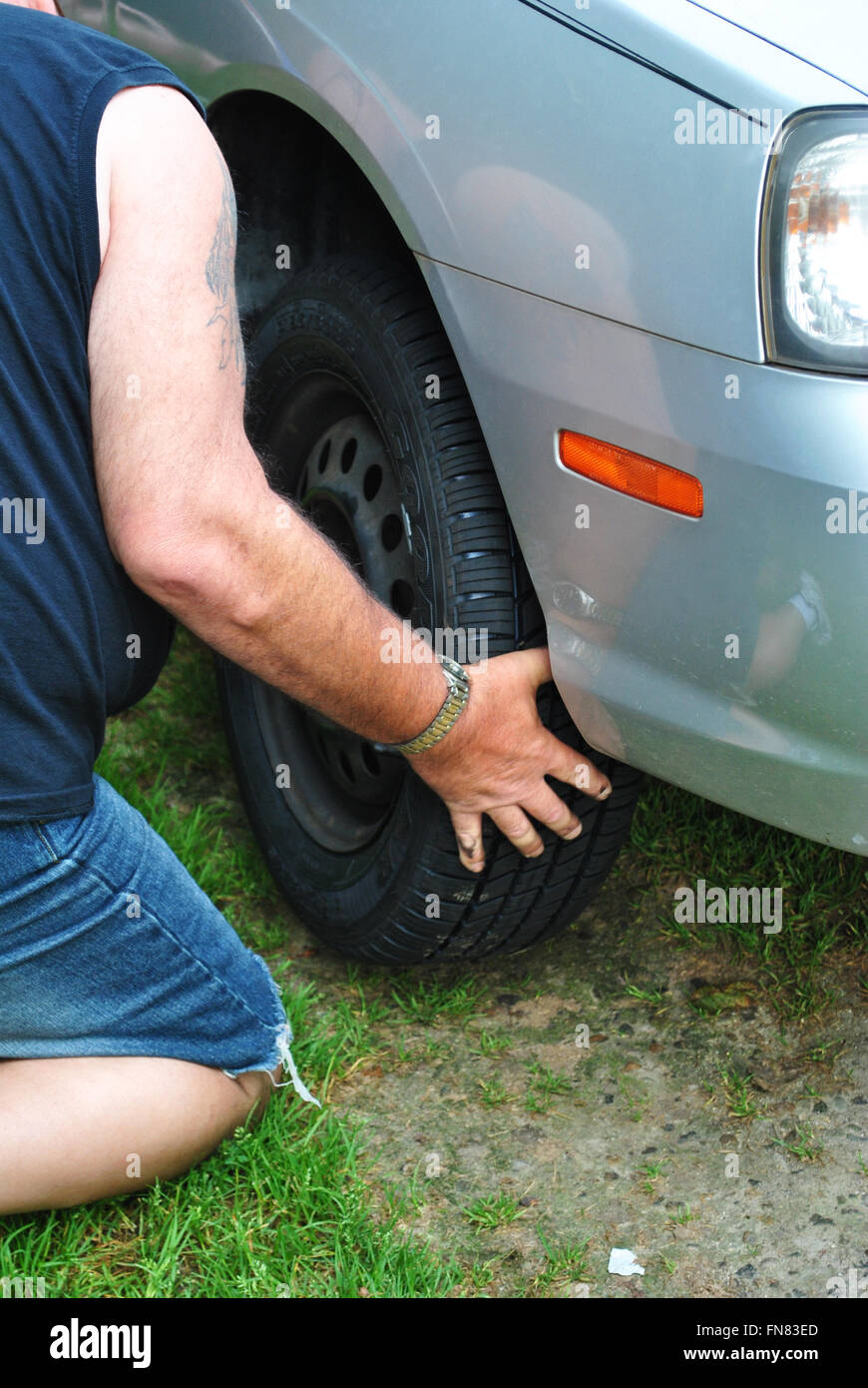 Man fixing a flat tire hi-res stock photography and images - Alamy