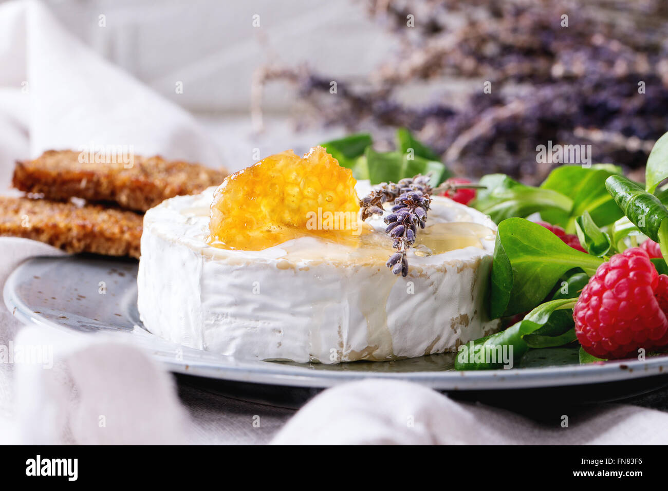 Goat cheese with honey and raspberries Stock Photo - Alamy