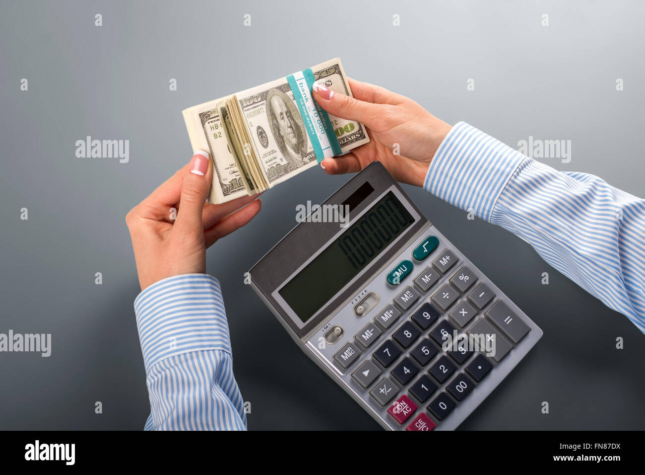 Woman counting money with calculator Stock Photo - Alamy