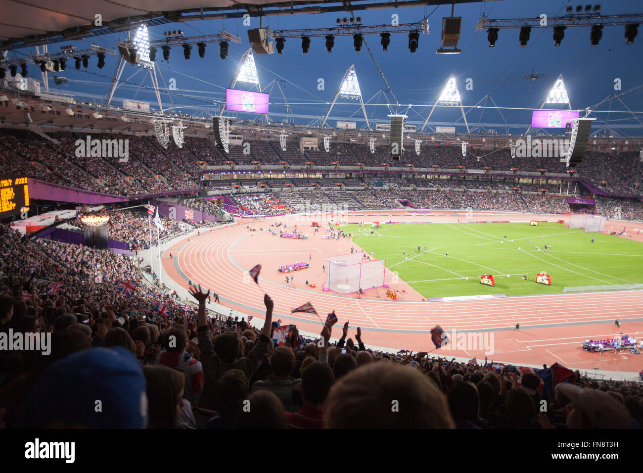 Fans cheering on athletes and night view of stadium during Paralympics ...