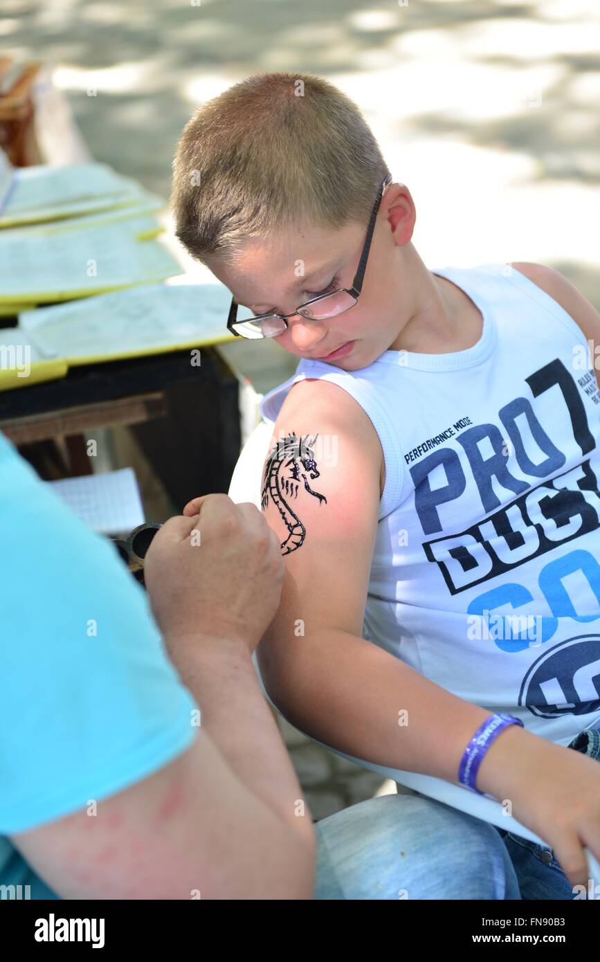 Boy having a temporary tattoo drawn on his arm Stock Photo - Alamy