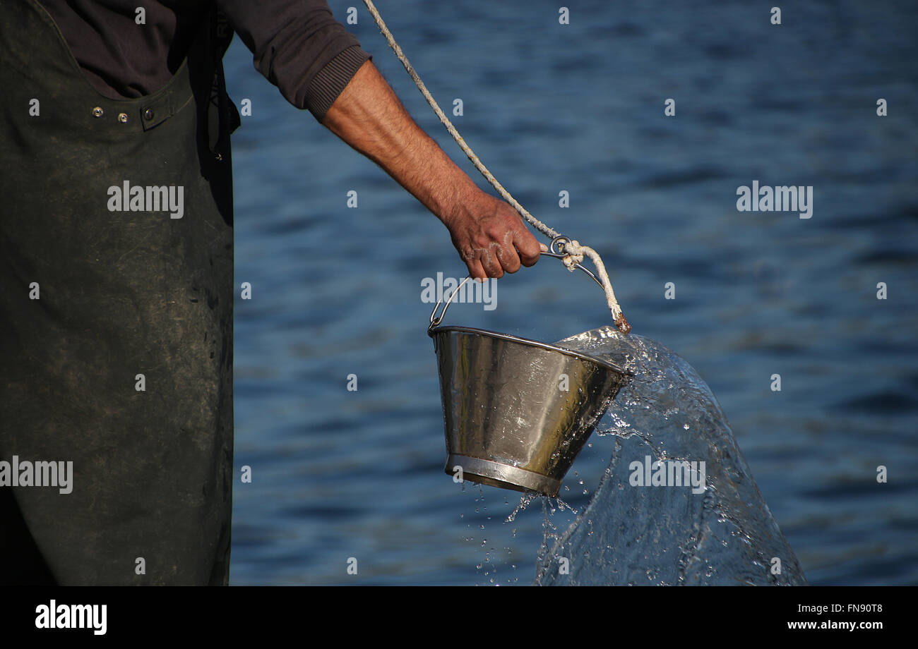 Fisherman holding a bucket Stock Photo - Alamy