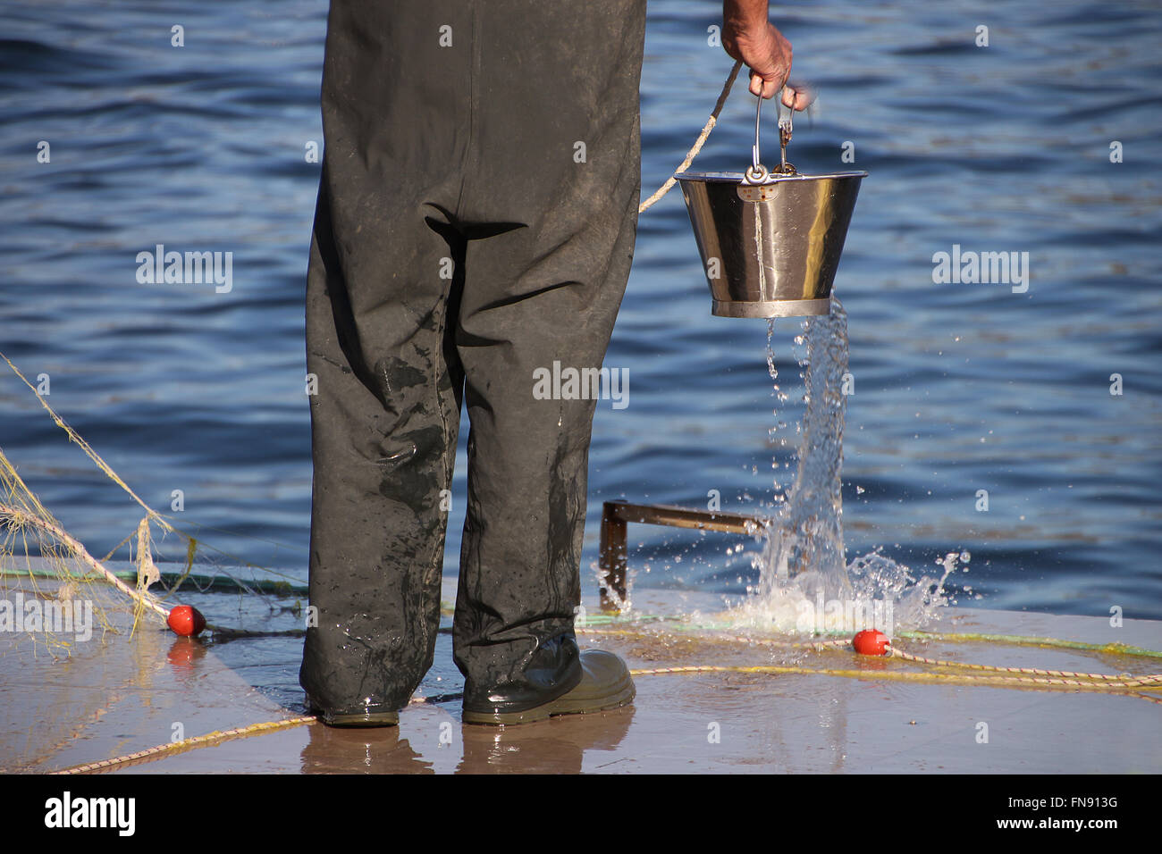 Fisherman holding a bucket Stock Photo - Alamy