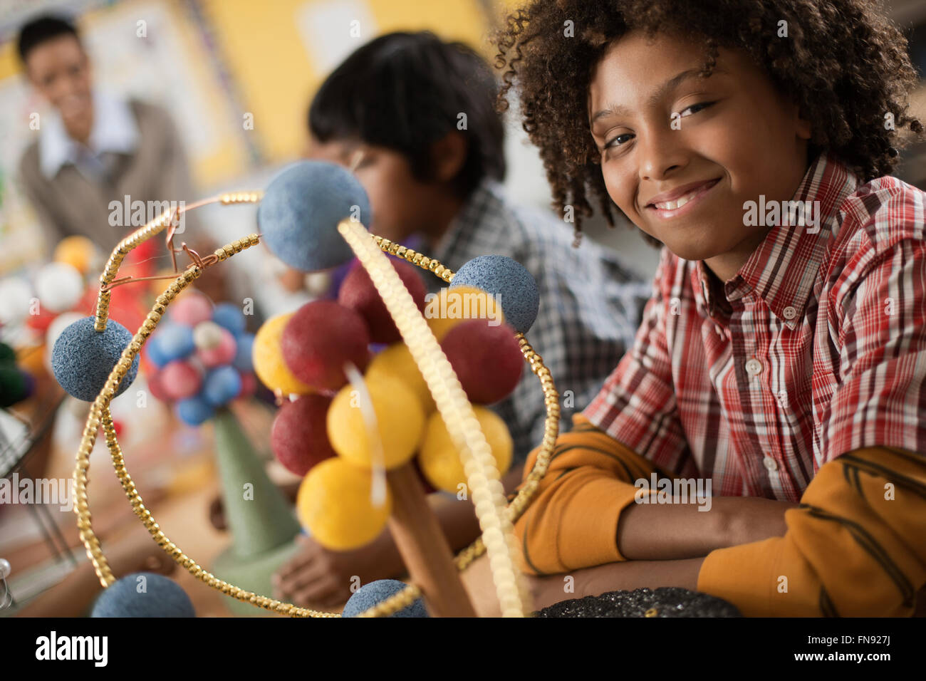 A group of students around a desk in a science lesson, creating ...