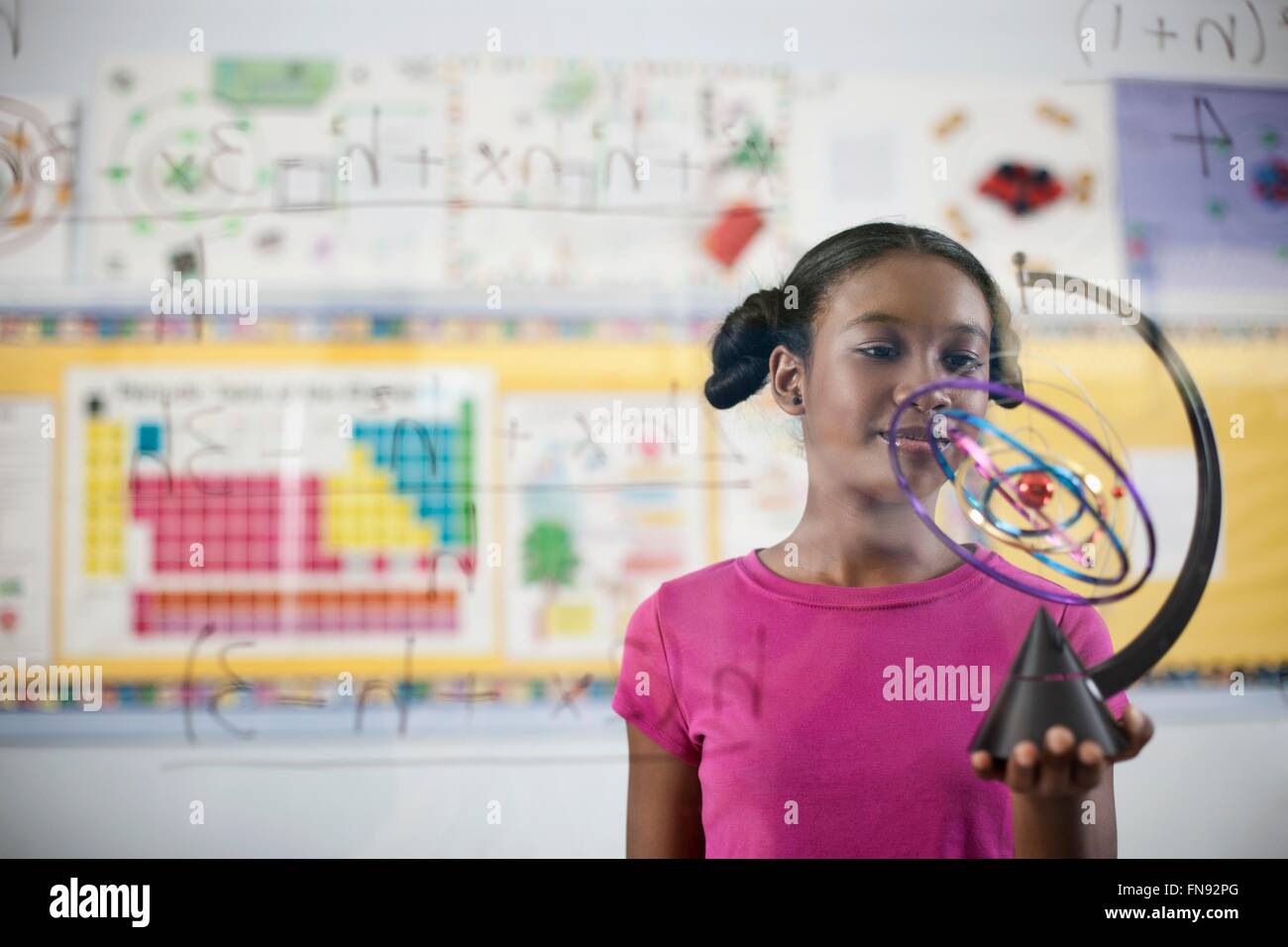 A student writing formula and equations on a clear perspex board, with ...