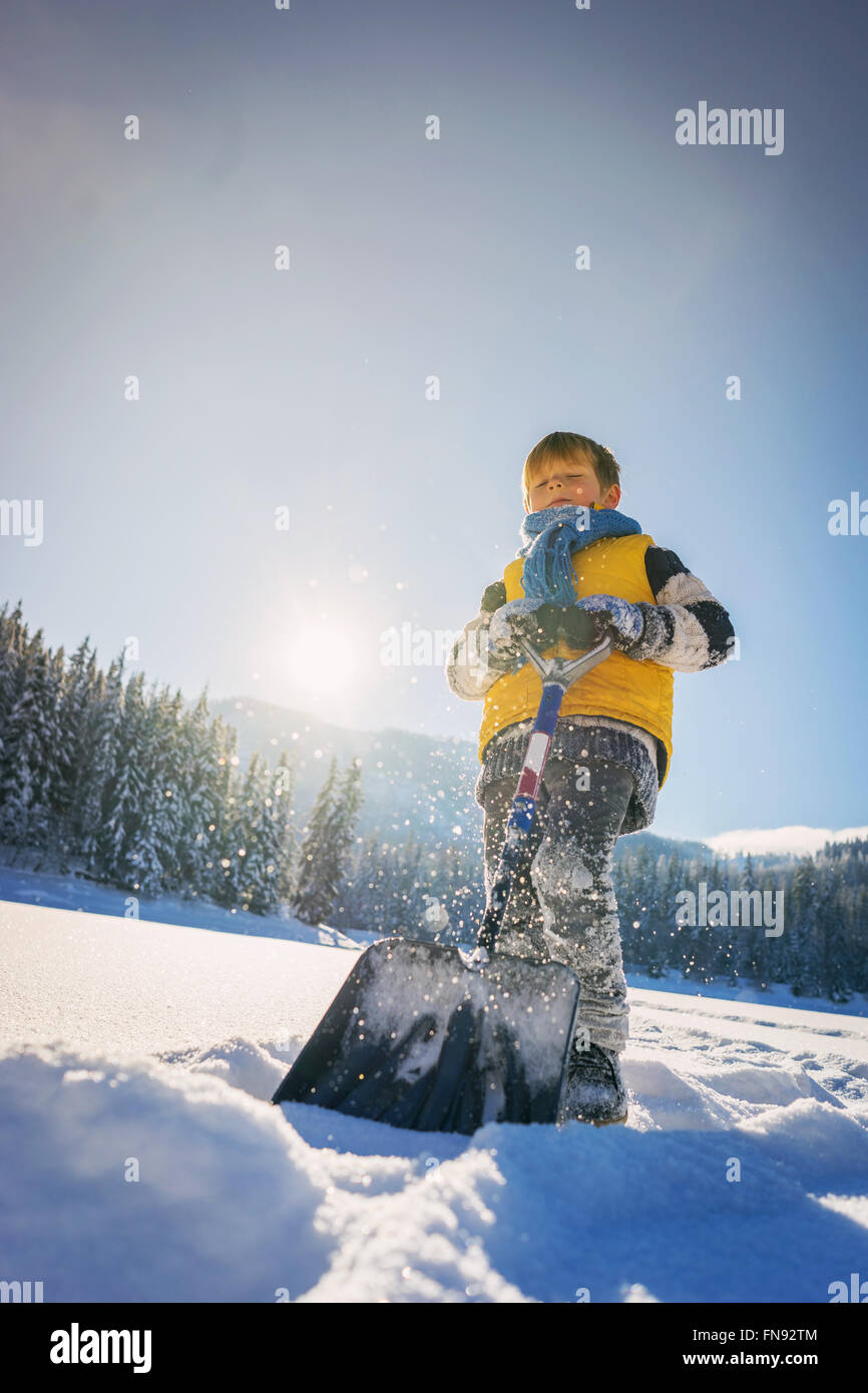 Low angle view of boy shoveling snow Stock Photo - Alamy